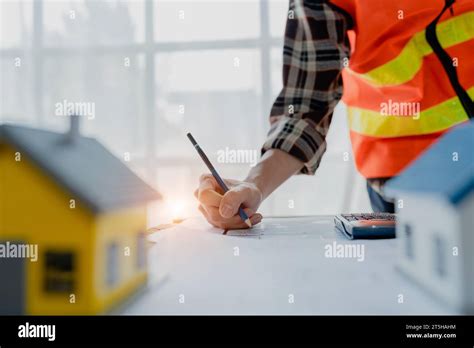 Engineer Brainstorming And Measuring For Cost Estimating On Blueprint