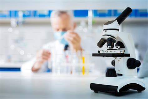 내 악기 화학 실험을 하고 배경으로 직장에 앉아 있는 동안 머리를 숙이는 세심한 과학자의 실루엣 사진 Unsplash의 실험실 코트 이미지