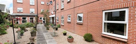 Pathway Alongside The Outside Of The Building Lined By Potted Plants