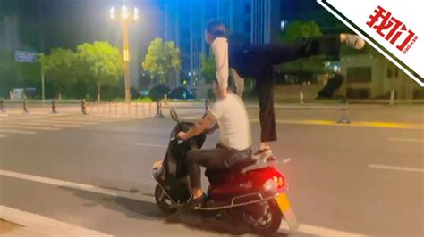 女子站在行驶中的摩托车上秀“杂耍”被查处 交警：已批评教育 腾讯新闻
