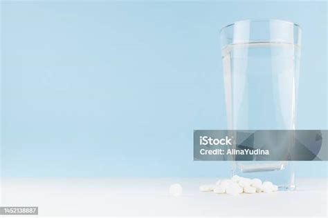 흰색 테이블과 파란 벽에 정제와 물 한 잔 건강 및 예방 테라 피 병 독감 감기 발열 두통 가정 의학 가슴 복사 공간을위한 의료 및 약국 치료 가벼운에 대한 스톡 사진 및