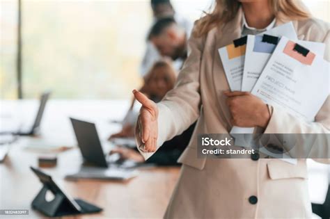 프로젝트 관리자가 문서를 들고 서 있습니다 직장인 그룹이 실내에 모여 있습니다 20 24세에 대한 스톡 사진 및 기타 이미지 20 24세 25 29세 경영자 Istock