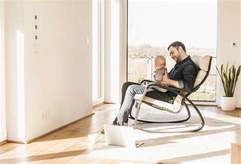 Vater Sitzt Im Sessel Mit Baby Auf Dem Scho Lizenzfreies Stockfoto