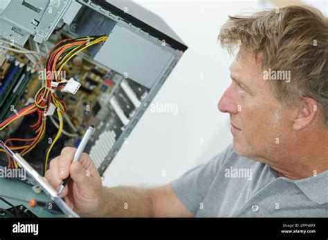 Mature Man Fixing A Pc Stock Photo Alamy