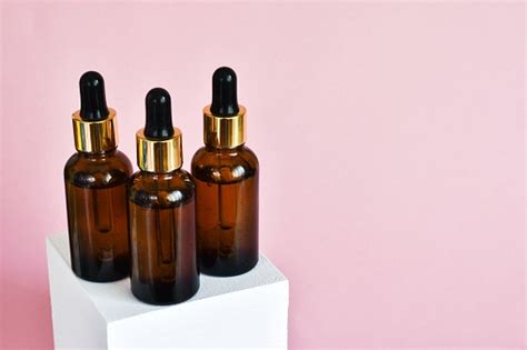 분홍색 배경에 흰색 연단에 파이펫이있는 갈색 유리 병에 천연 히알루론 세럼 복사 공간을 복사합니다 대체 의학 방향족 화장품 스킨 케어 제품 광고 0명에 대한 스톡 사진 및