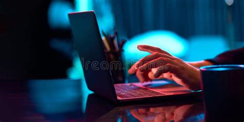 Businessman Working Remotely Typing On Laptop Keyboard Over Neon Lights Home Office In Neon