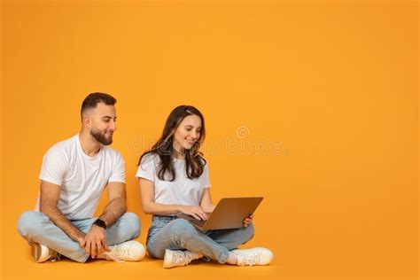 A Relaxed Man And Woman Sitting Cross Legged On The Floor With The