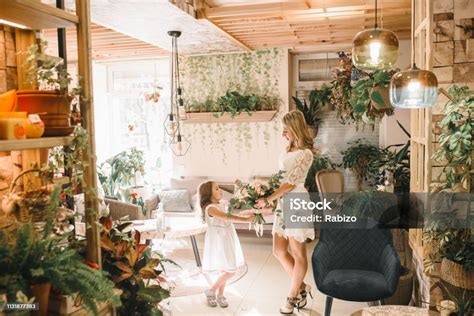 엄마와 딸은 카페에서 꽃으로 아들은 어머니에 게 꽃을 주고 있습니다 귀여운 가족입니다 세계 여성의 날 3 월 8 일 축 하 2명에 대한 스톡 사진 및 기타 이미지 Istock