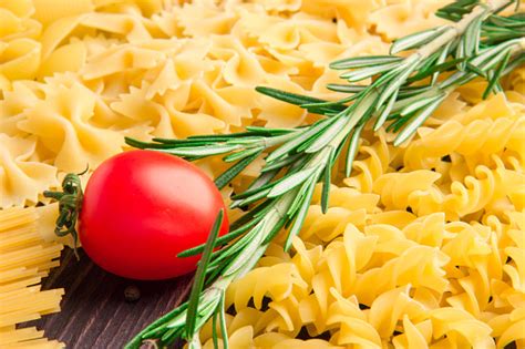 다양 한 종류와 형태의 건조 마 카로 니 토마토와 로즈마리 이탈리아 마 카로 니 원시 음식이 나 질감 파스타 스파게티 파스타는 나선형의 형태로 건강한 생활방식에 대한 스톡