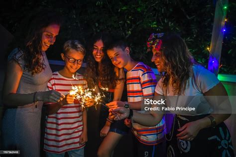 테라스에서 불꽃놀이와 함께 파티를 만드는 다양 한 사람들의 그룹 가족 생일을 축하하는 스파클러를 즐기며 함께 즐거운 시간을 보내는 소녀와 소년 청소년 행복과 휴일 개념 12