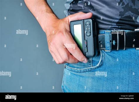 Hand Holds Pager Weighing On Belt Jeans Stock Photo Alamy