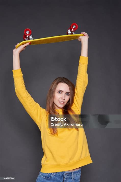 노란 블라우스와 노란색 스케이트 보드를 들고 청바지를 입고 긍정적인 젊은 매력적인 여자의 초상화입니다 귀여운에 대한 스톡 사진 및 기타 이미지 Istock
