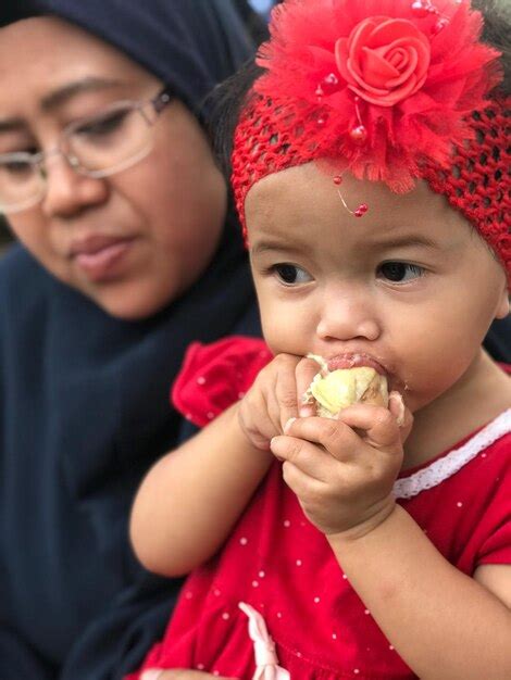 Premium Photo Close Up Of Daughter Eating Food By Mother