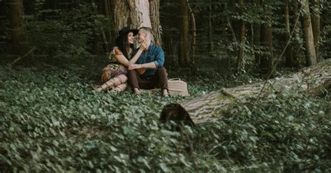 행복한 젊은 가족 남자와 여자 숲에서 산책을 즐기고 큰 나무 아래에 앉아 포옹하고 키스하는 야외 전체 길이 샷 숲속의 나무 아래에 앉아 있는 임신한 부부 사진