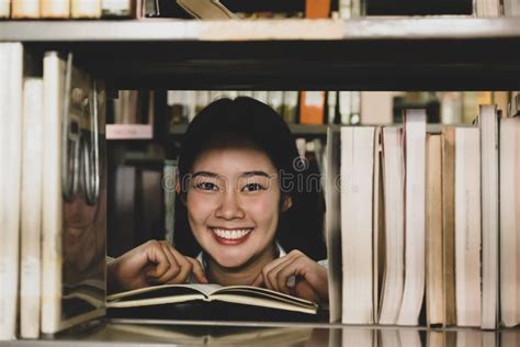Young Asian Female College Students Research And Learn From Textbooks