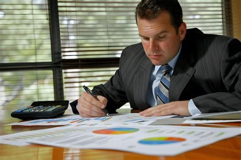 Business Person Analyzing Charts And Graphs At Desk Premium Ai