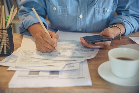 예산 계획 개념 회계사는 회사의 연간 세금을 계산하고 있습니다 달력 2022 및 미국 법률에 따라 소득이 있는 사람들을 위한 개인 소득세 양식이 사무실 책상에 놓여 있습니다