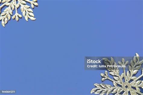 눈송이가 있는 크리스마스 배경 파란색 배경에 반짝이는 두 개의 은백색 눈송이가 배치됩니다 새해 복 많이 받으세요 즐거운 성탄절 엽서 또는 초대장 공간을 복사합니다 플랫 레이