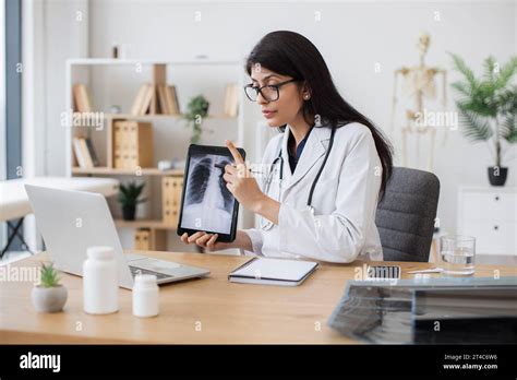 Concentrated Female Doctor Talking On Video Call While Showing Result