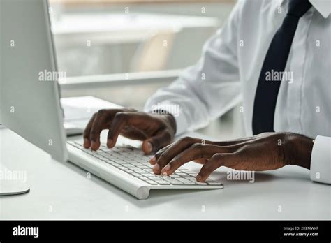 Close Up Of African American Businessman Typing On Keyboard While Working On Computer At Office