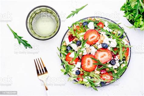 딸기와 허브 Arugula 블루 베리 부드러운 흰색 페타 치즈와 호두 흰색 주방 테이블 텍스트를위한 장소와 함께 건강한 샐러드 건강한 식생활을위한 신선한 유용한 요리 0명에