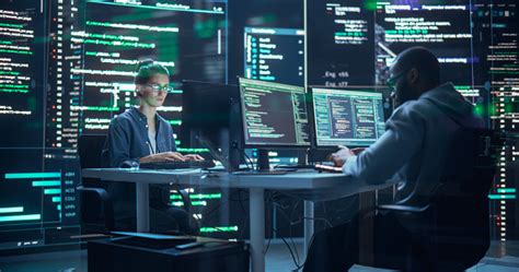 Portrait Of Two Diverse Developers Working On Computer Typing Lines Of