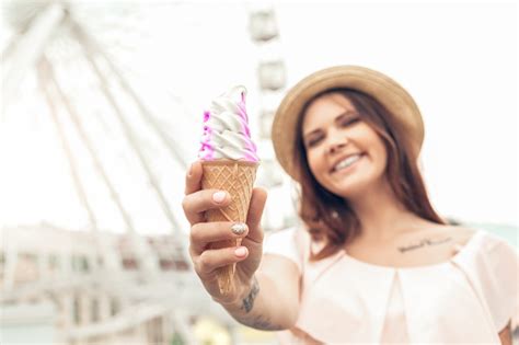 우리의 실내 레저 아이스크림 콘 잃어버린 배경 이밝게 웃고 있는 관람차 근처 거리에서 걷는 모자를 쓴 소녀 갈색에 대한 스톡