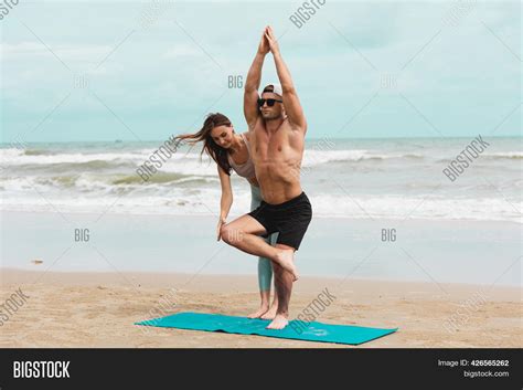 Couple Yoga On The Beach
