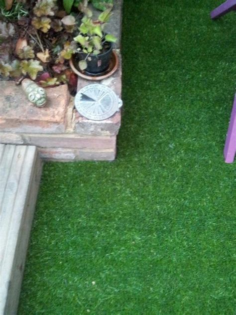 Artificial Grass Carefully Cut Using Scissors Around A Raised Bed