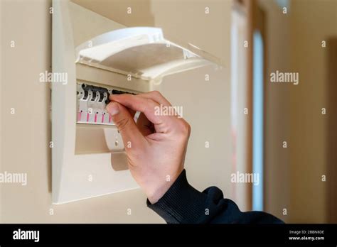 Hand Switching Power Switch On A Fusebox Close Up Of Electrician Checking Fuse Box Knob Stock