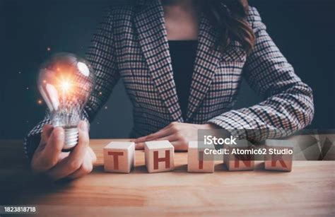 전구를 들고 있는 사업가와 나무 블록 와 알파벳 텍스트 나무 테이블 Think 창의성 아이디어 교육 공부 자기 학습 지식 혁신 영감 개념의 개념 개념에 대한 스톡 사진 및