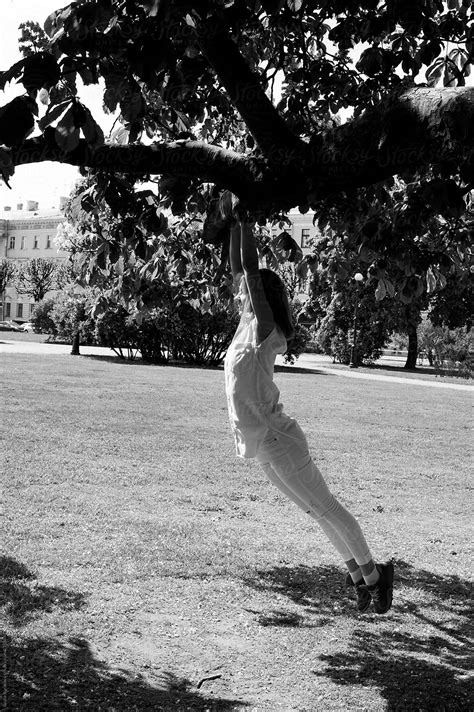 Woman Swinging On Tree Branch By Stocksy Contributor Amor Burakova Stocksy