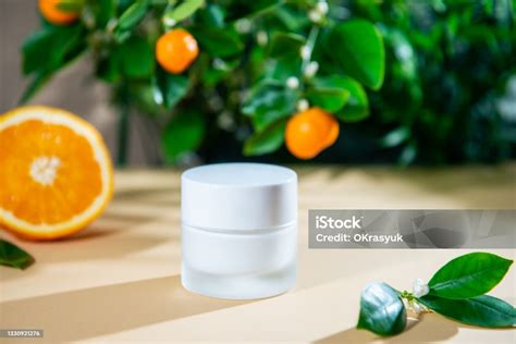 천연 감귤류 에센셜 오일과 귤 나무 오렌지 과일 배경으로 보습 페이스 크림의 닫힌 항아리를 닫습니다 스킨 케어 뷰티 제품에 대한 모형 비타민 C 화장품 공간을 복사합니다 0
