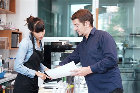 웃는 백인 젊은 바리스타 여성은 커피 숍의 카운터에서 메뉴를 들고 고객 사업가의 음료 목록 메뉴를 권장합니다 작은 카페 비즈니스 및 기술 개념을 시작하십시오 성년 여자에