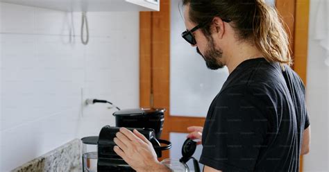 카운터 옆 부엌에 서 있는 남자 사진 Unsplash의 다르게 능력 이미지