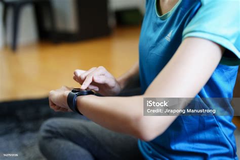 건강 관리 심박수 모니터 요가 유산소 운동 호흡 명상과 같은 건강 프로그램을 선택하기 위해 스마트 워치를 사용하는 아시아의 아름다운 여성의 초상화 활동 전에 준비하려면
