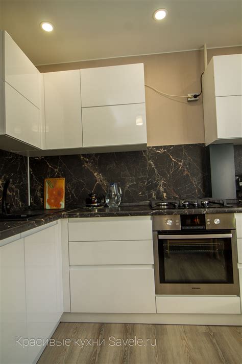 Белоснежная кухня с черным фартуком и столешницей