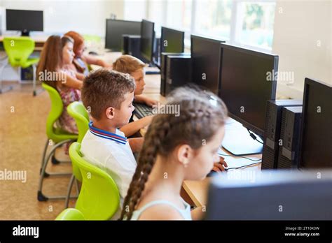 Male And Female Babes Using Computers While Sitting At Desk In Classroom Stock Photo Alamy