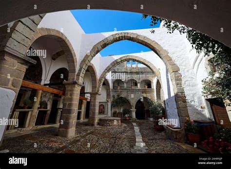 Historic Courtyard Of A Monastery With Arches And Stone Structures Under A Blue Sky Inside The
