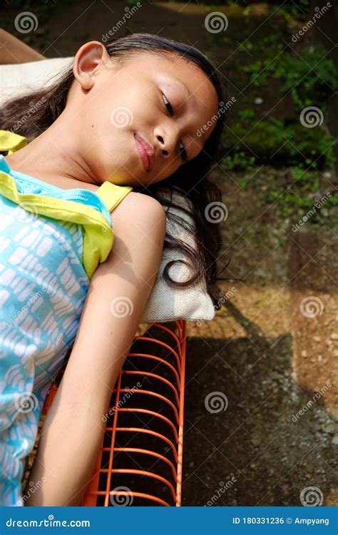 Красивая азиатская девочка лежит на скамейке этнической принадлежности для дома утром Стоковое