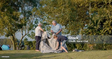 자연 보호 구역에 텐트를 설치하는 조부모 어머니 아들과 함께 가족 캠핑하는 사람들의 솔직한 사진 주말 팀워크 황혼 시간에 저녁에 자연 속에서 함께 활동으로 유대감을