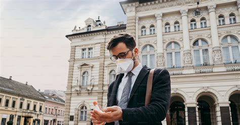 알코올 스프레이를 사용하여 손을 소독하는 보호 얼굴 마스크를 쓴 우아한 사업가 바이러스 전염병 또는 전염병 개념 사진 Unsplash의 세르비아 이미지