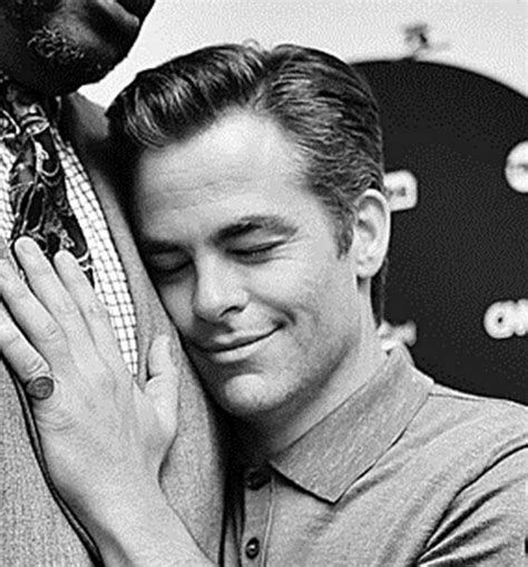 Two Men Hugging Each Other In Front Of A Microphone
