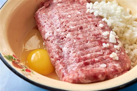 흰 양파와 닭고기 달걀을 뿌린 신선한 쇠고기와 돼지고기 다진 고기를 노란 철판에서 절단 하 고 닭 꼬치로 만들어 냅니다 고기 분쇄기에 꼬인 고기 가루로 빻은에 대한 스톡