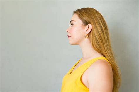 긴 금발 머리를 한 여성이 스튜디오에 우아하게 서서 현대적인 스타일과 자연스러운 아름다움을 발산하는 프로필 뷰 건강한 생활방식에 대한 스톡 사진 및 기타 이미지 Istock