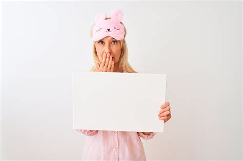 중년 여성 수면 마스크 잠옷을 입고 배너를 들고 고립된 흰색 배경 커버 입에 실수 두려움의 표정 침묵 비밀 개념에 대한 수치심으로 충격을 받았다 가리기에 대한 스톡 사진 및