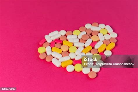 많은 다른 알 약과 정제 핑크 배경에 심장의 모양으로 접혀 텍스트에 대 한 공간이 많은 알 약과 정제 의료 맨 위 보기입니다 공간을 복사합니다 새 이미지 제약 사진 근접