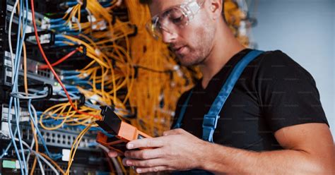 측정 장치가 있는 제복을 입은 청년은 서버실에서 인터넷 장비와 전선으로 작업합니다 사진 Unsplash의 우크라이나 이미지