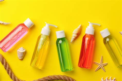 Colorful Bottles Of Sunscreen With Seashells On Yellow Background Stock