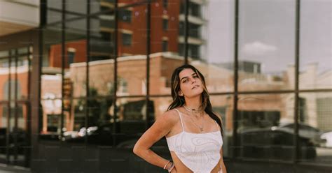 엉덩이에 손을 얹고 보도에 서 있는 여자 사진 Unsplash의 유행 이미지